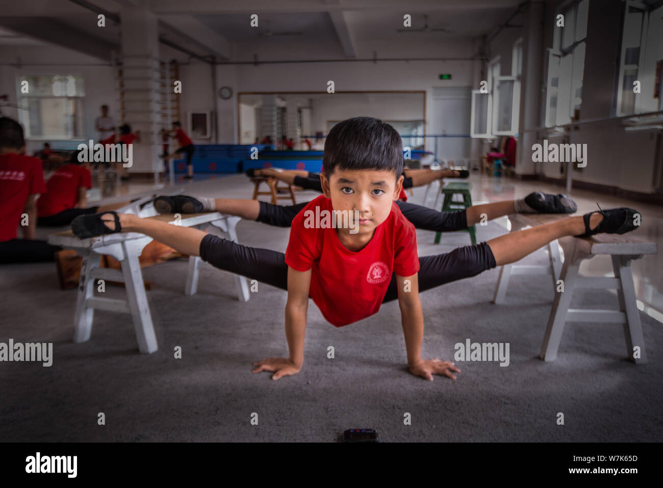 Chinese children do the splits to keep balance with their hands on the ...