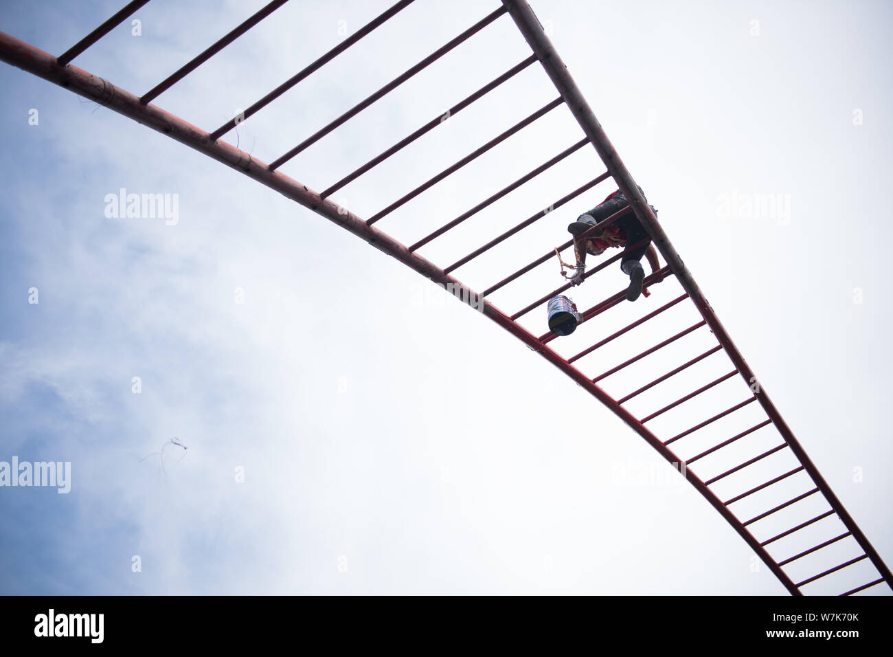 A Chinese worker climbs an arched ladder, which looks like a "ladder to ...