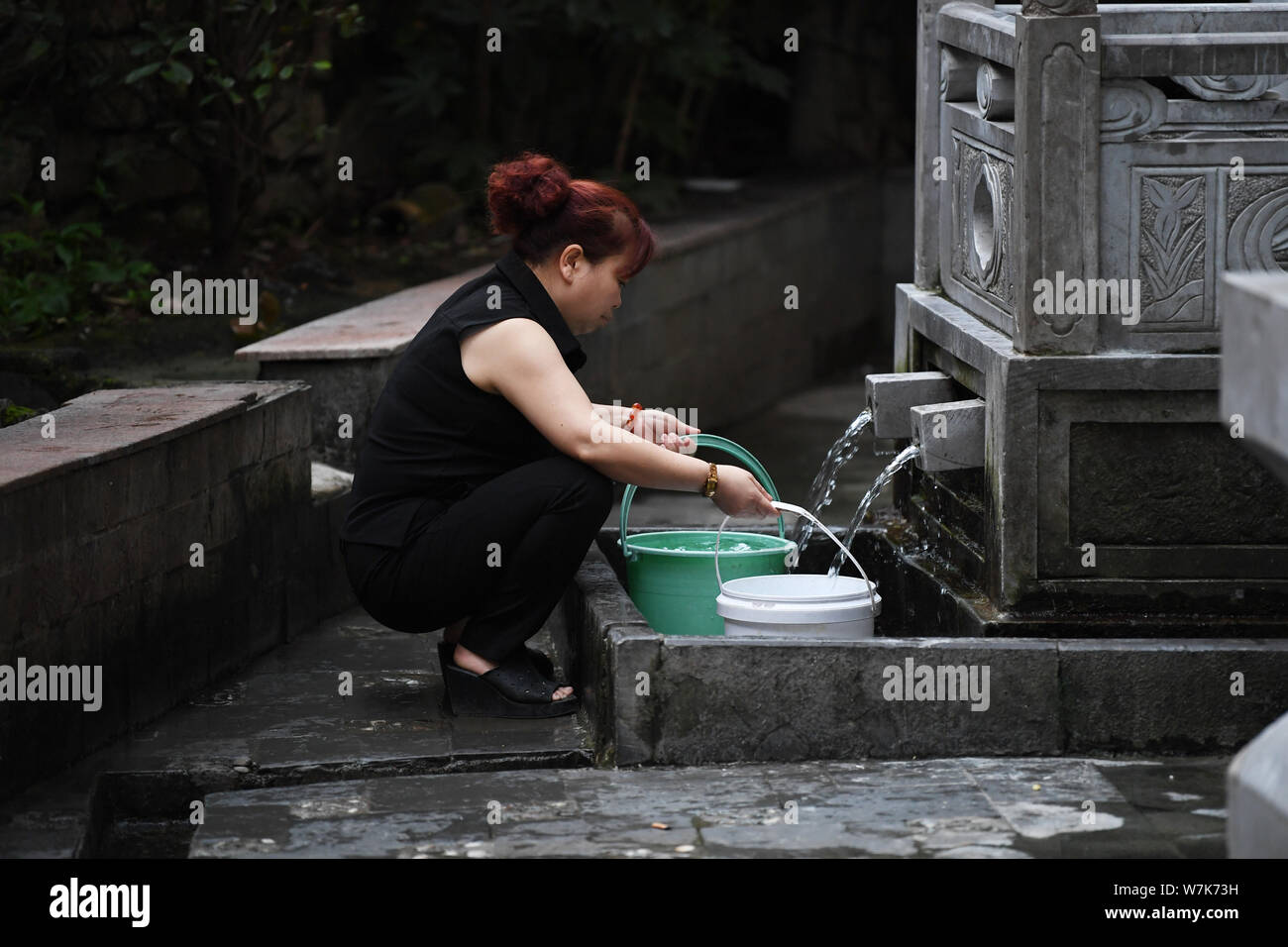 A nearby resident fetches the well water from the 600-year-old Yujing ...