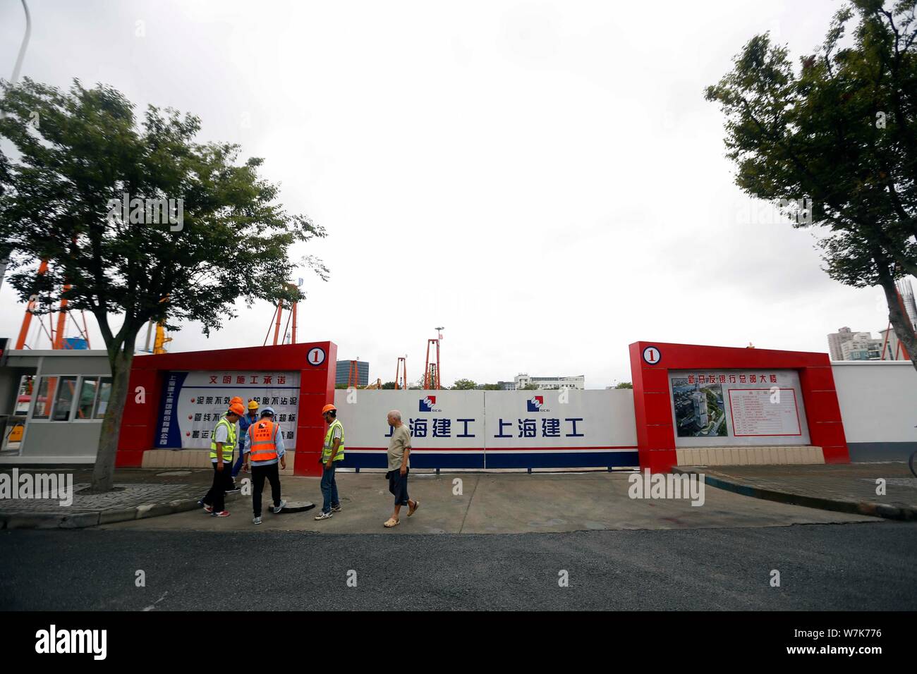 Chinese workers walk past the construction site of the headquarters for ...