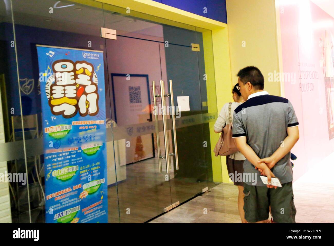 Customers look at a closed store of the O2O Piano Teaching Platform ...