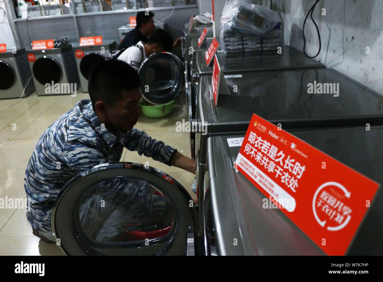 A college student uses a shared clothes dryer at the laundry in the ...