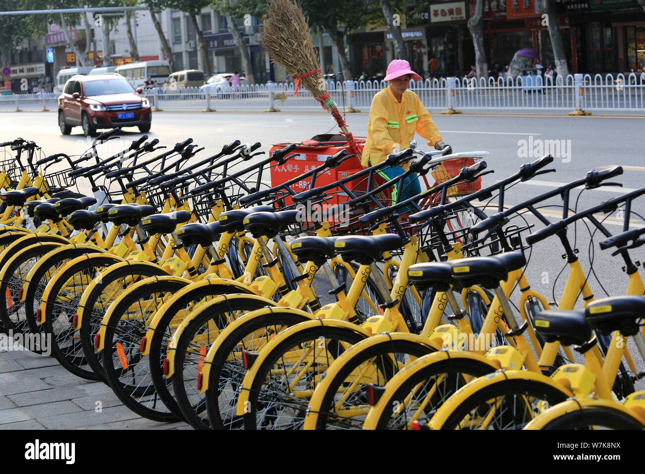 --FILE--A Chinese worker rides past bicycles of Chinese bike-sharing ...