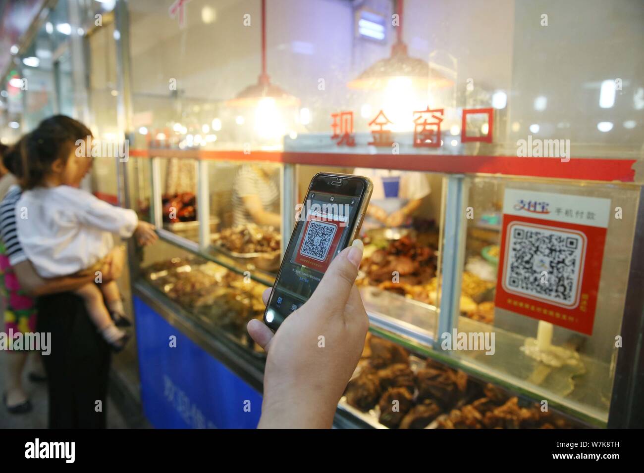 --FILE--A Chinese customer scans a QR code via mobile payment service ...