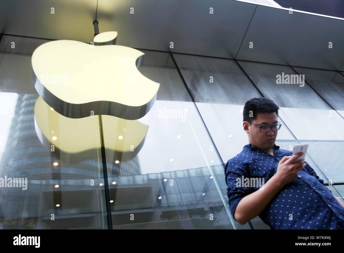 --FILE--A pedestrian uses his smartphone in front of the Apple Store on ...