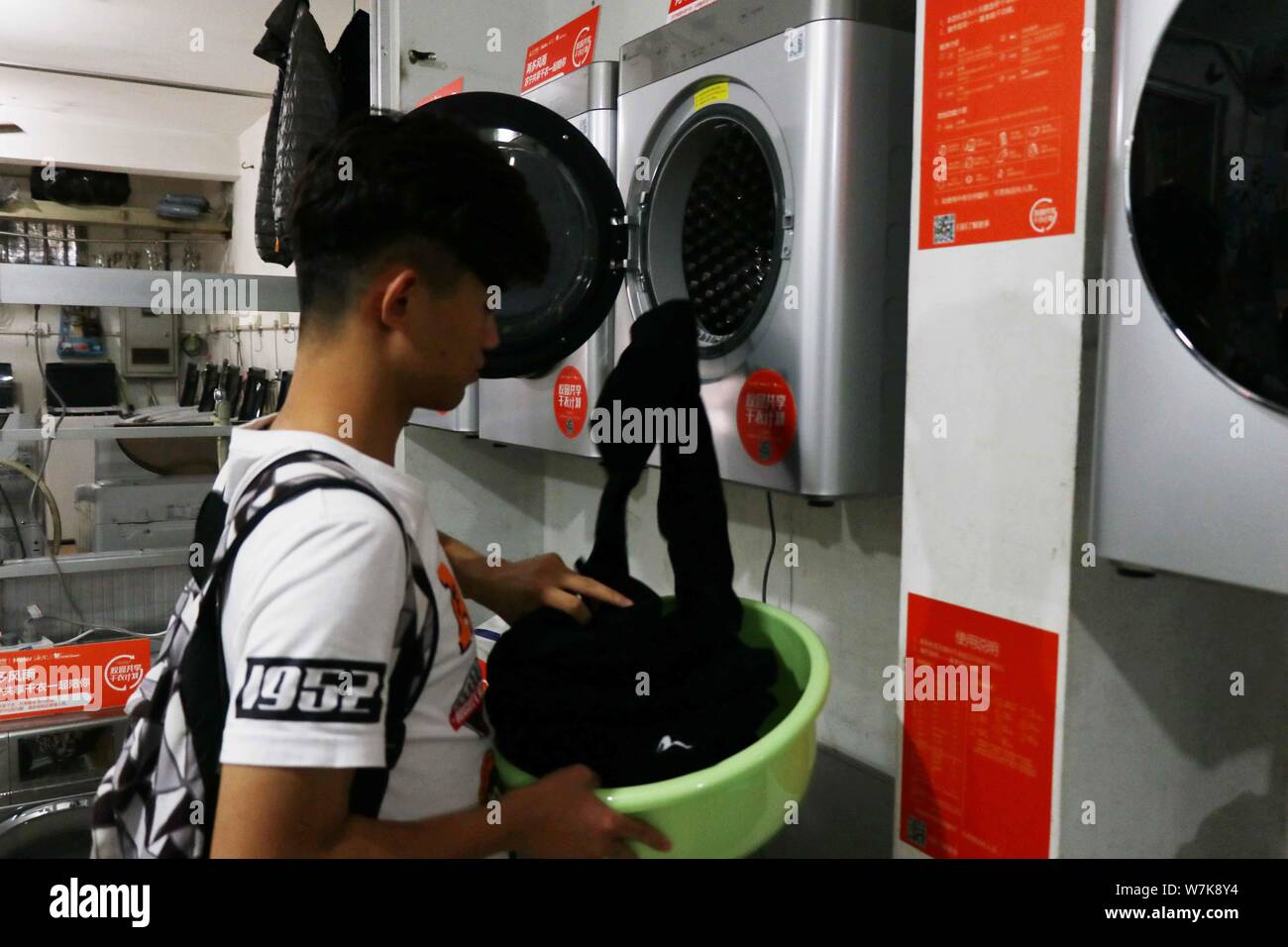 A college student uses a shared clothes dryer at the laundry in the ...