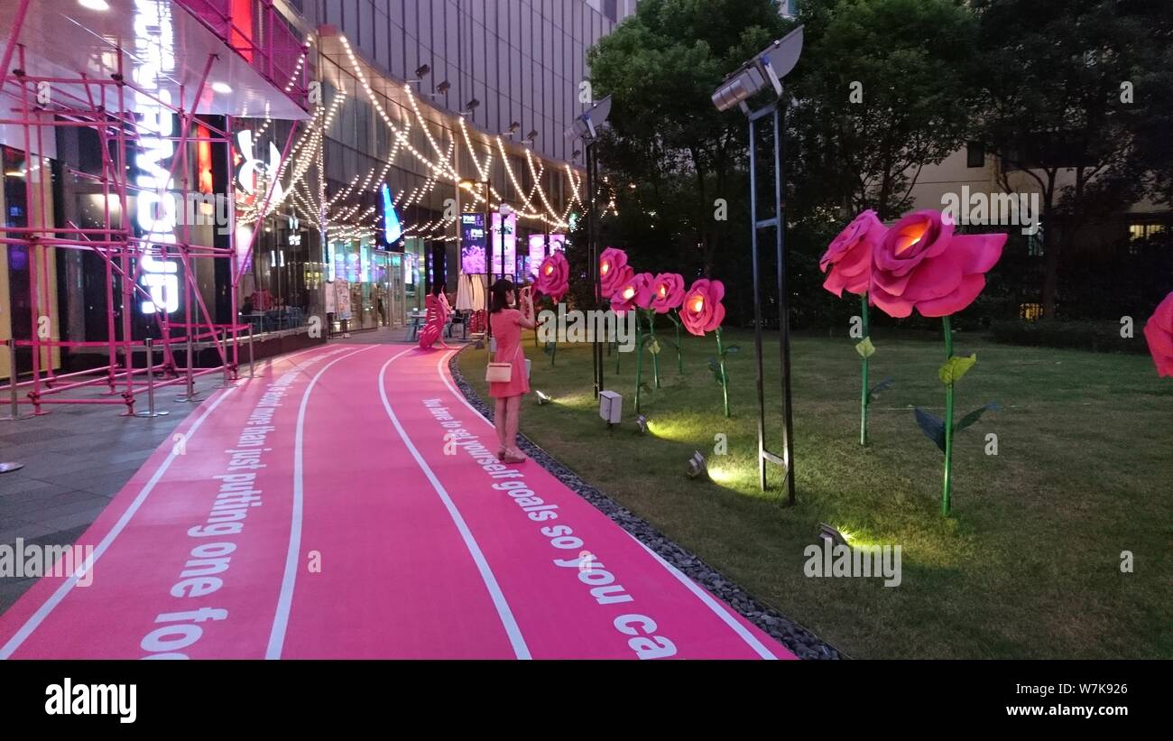 A customer takes photos of pink installations on display at the Crystal ...