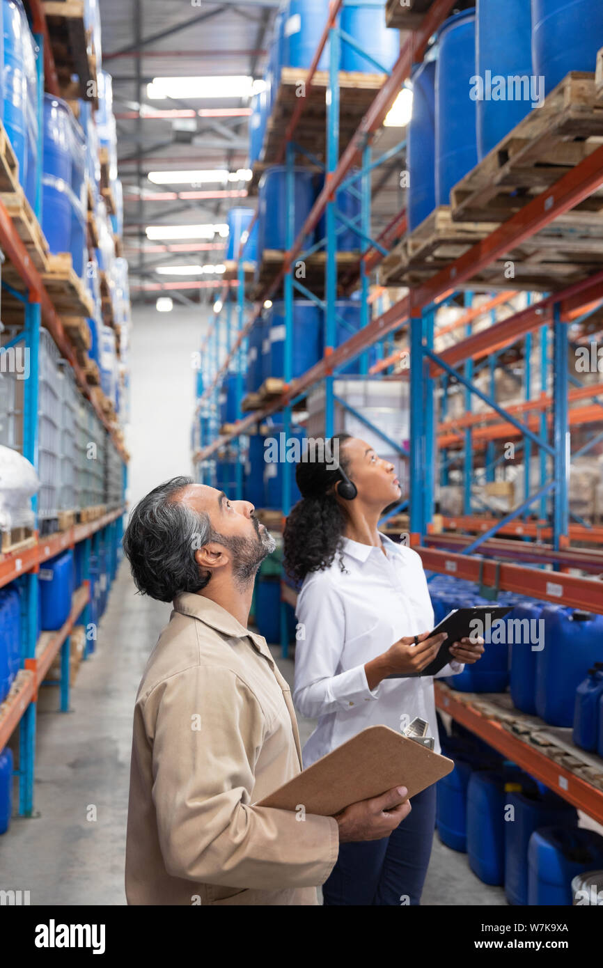 Female manager and male staff checking stocks in warehouse Stock Photo ...