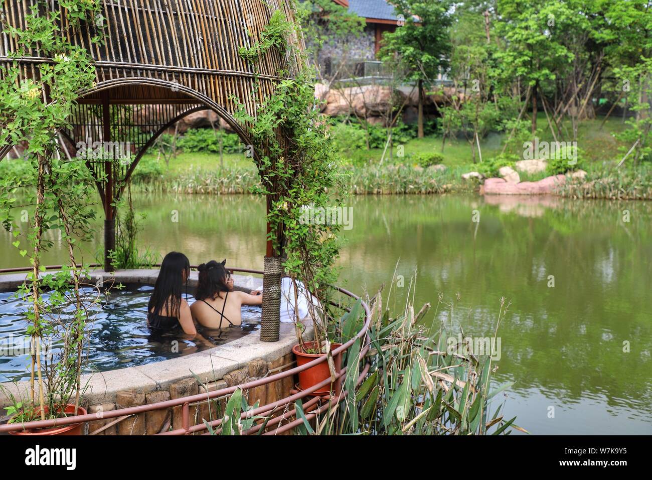 Chinese holidaymakers enjoy themselves in a pool in the shape of ...
