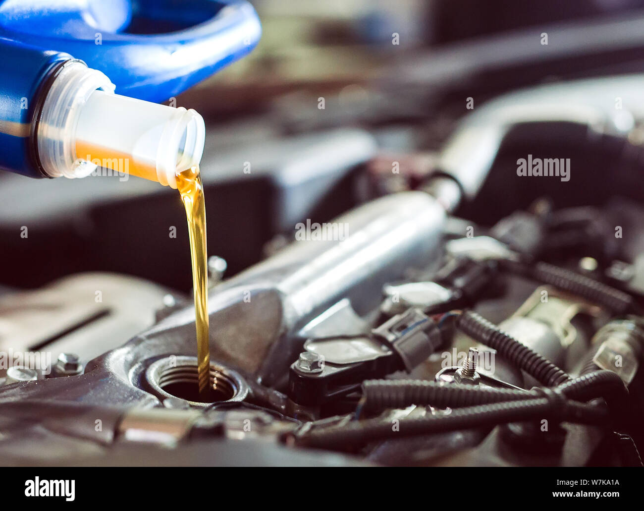 Motor oil pouring to car engine. A service station Stock Photo - Alamy