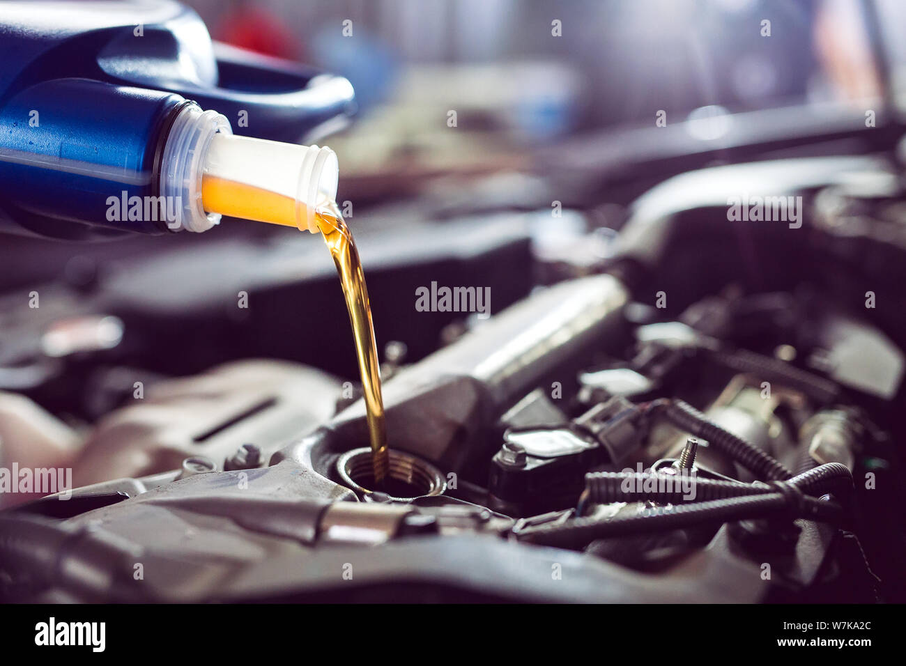Motor oil pouring to car engine. A service station Stock Photo - Alamy