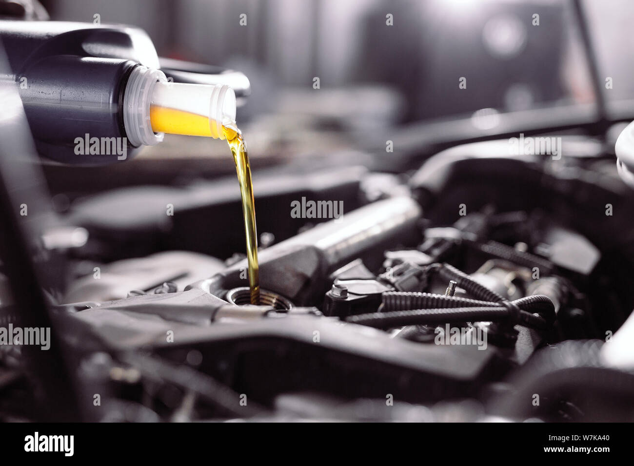 Motor oil pouring to car engine. A service station Stock Photo - Alamy