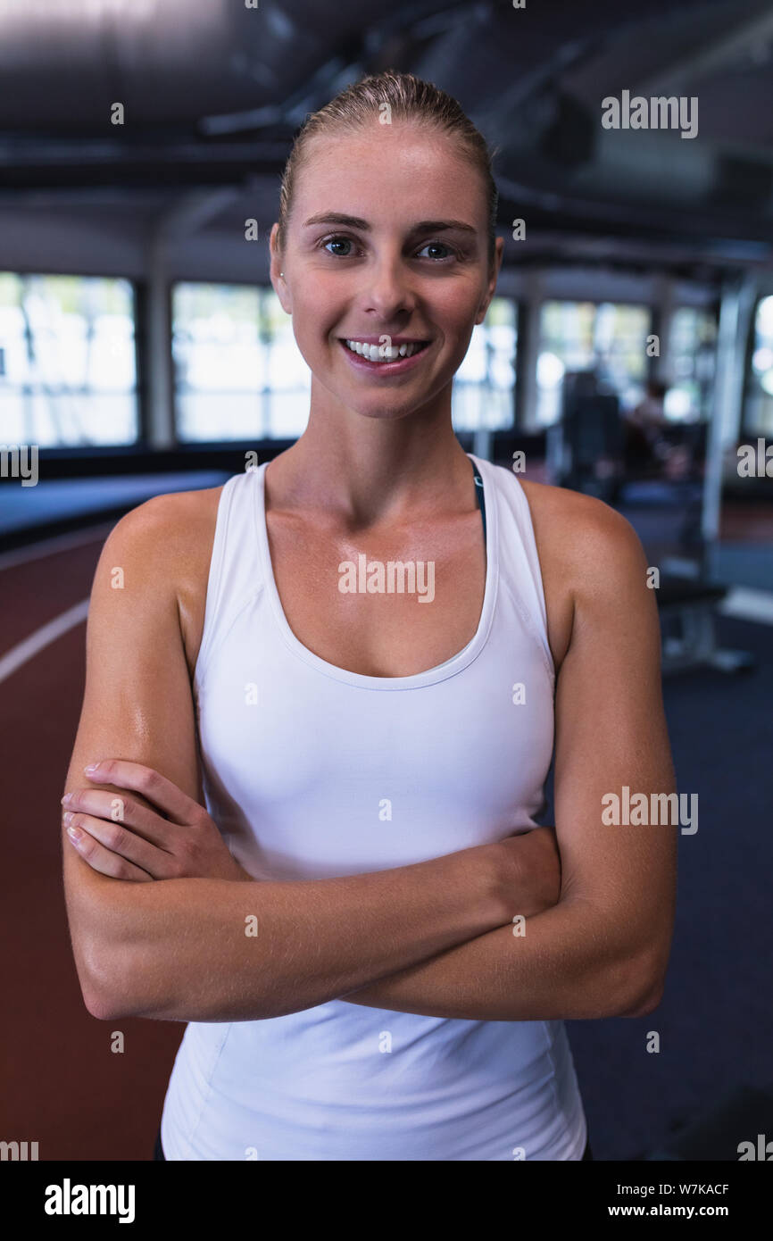 Female athletic standing with arms crossed in fitness center Stock ...