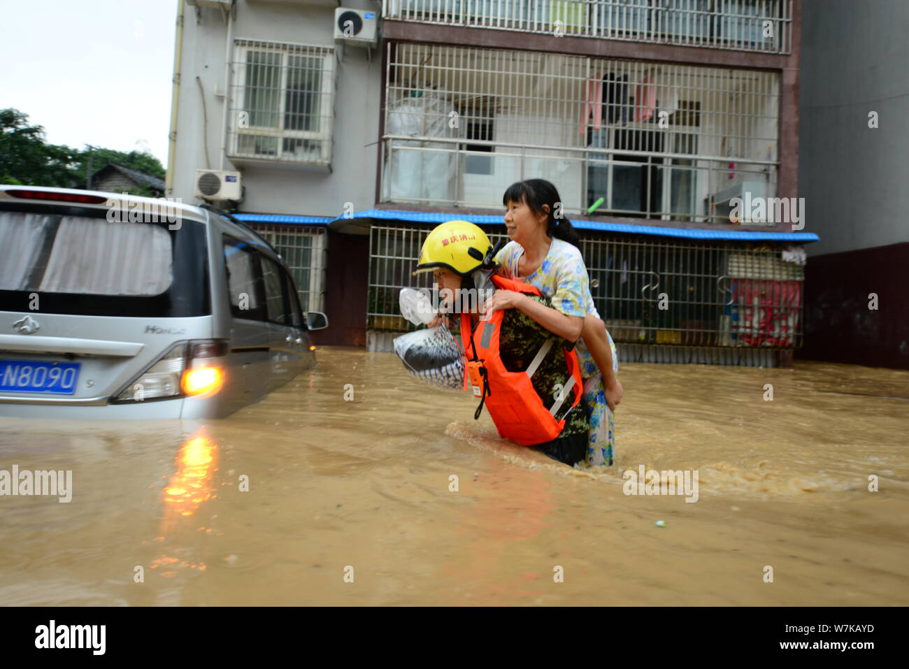 A Chinese rescuer carries a local resident to evacuate from flooded ...