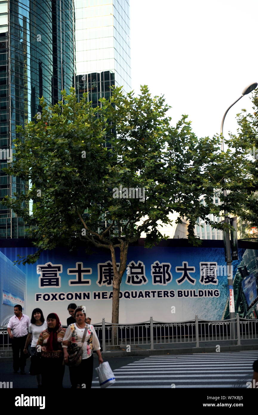 --FILE--Pedestrians walk past the Foxconn headquarters building under ...