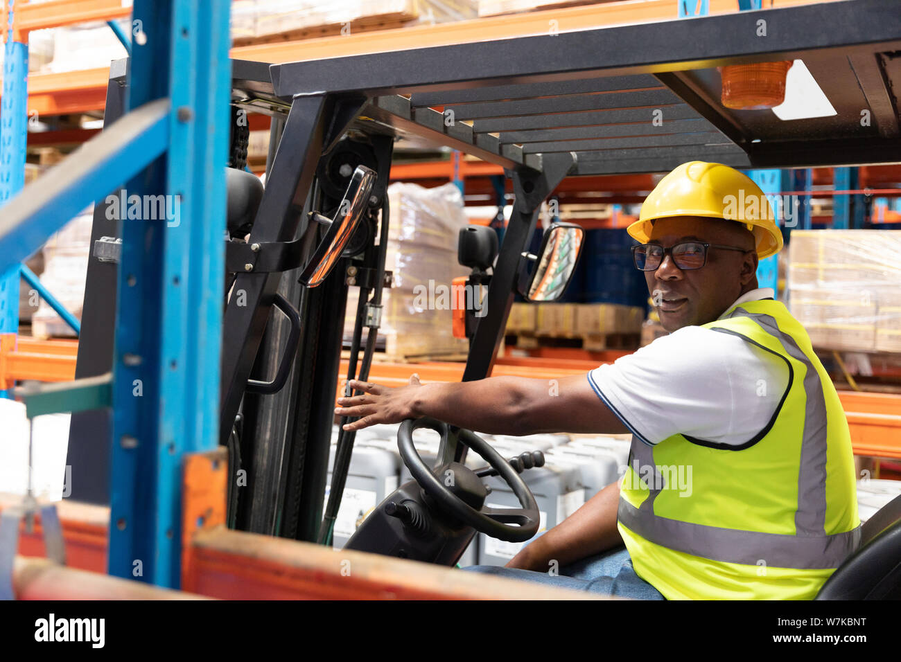 Male staff driving forklift in warehouse Stock Photo - Alamy