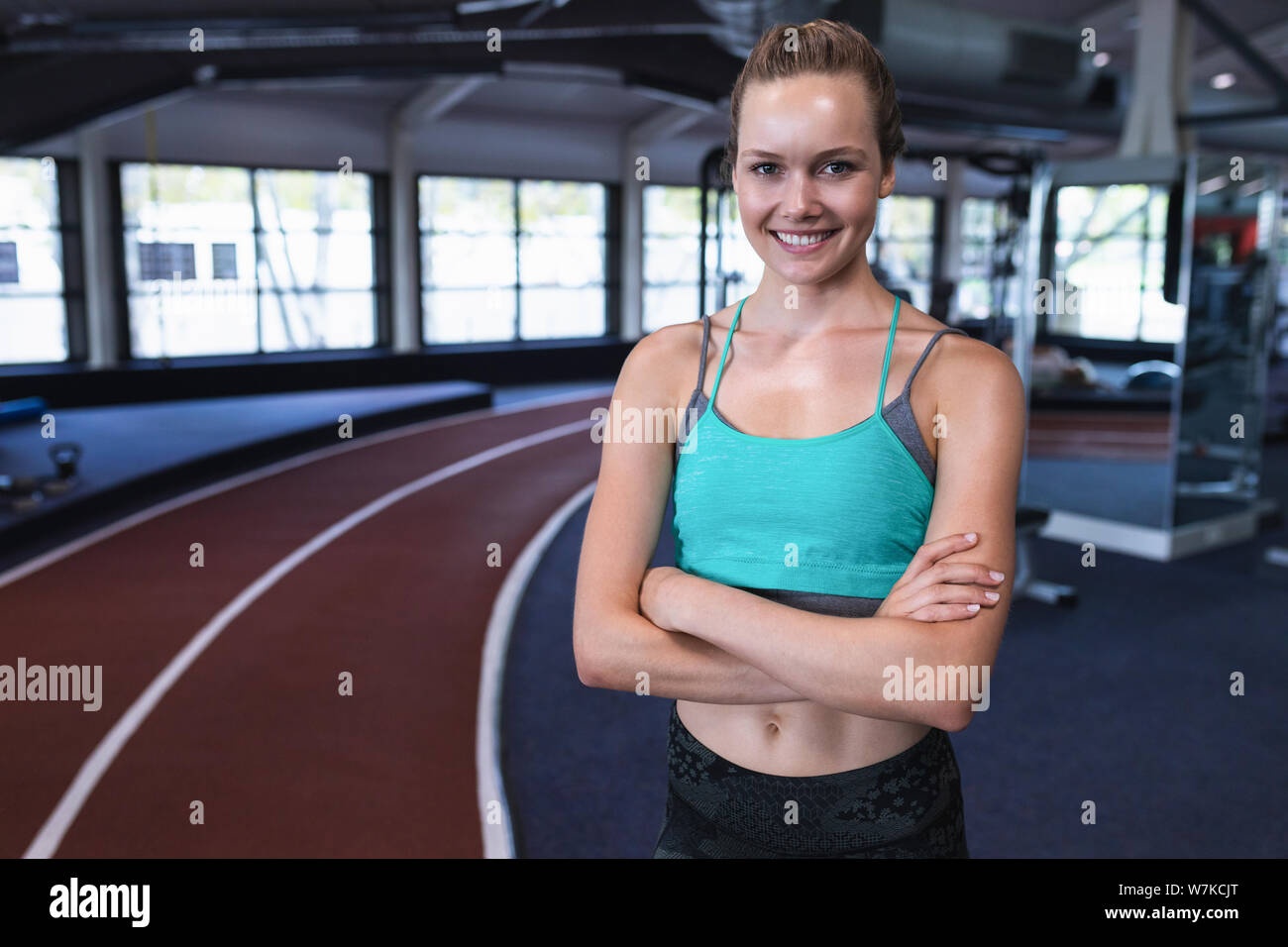 Female athletic standing with arms crossed in fitness center Stock ...