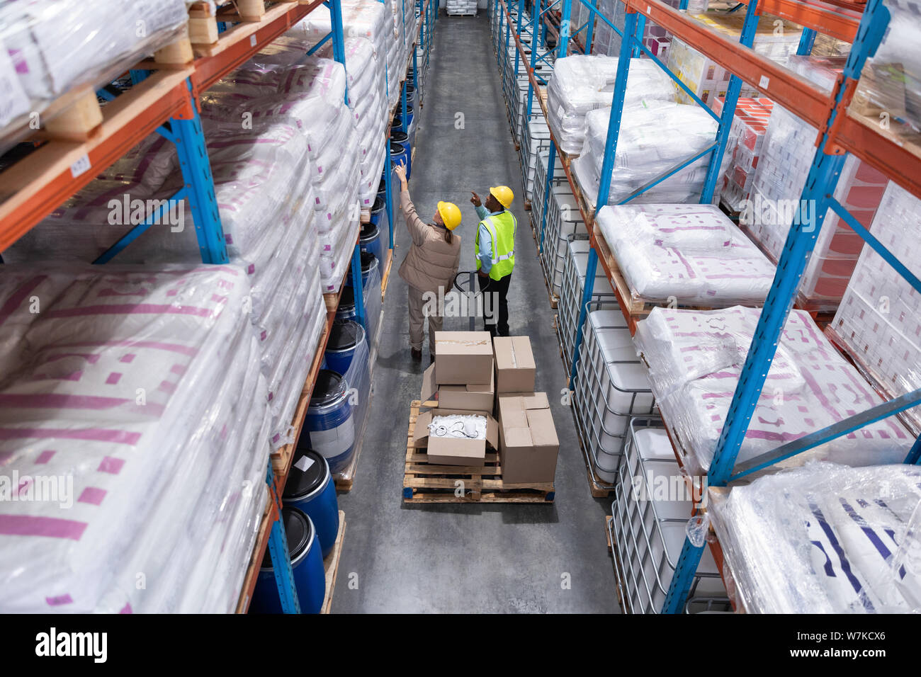 Female staff interacting with her coworker in warehouse Stock Photo - Alamy