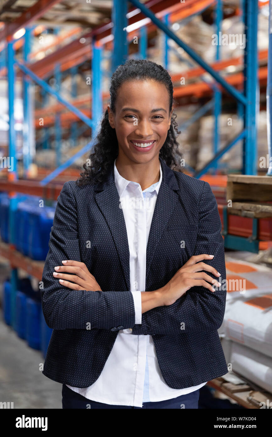 Female manager standing with arms crossed in warehouse Stock Photo - Alamy