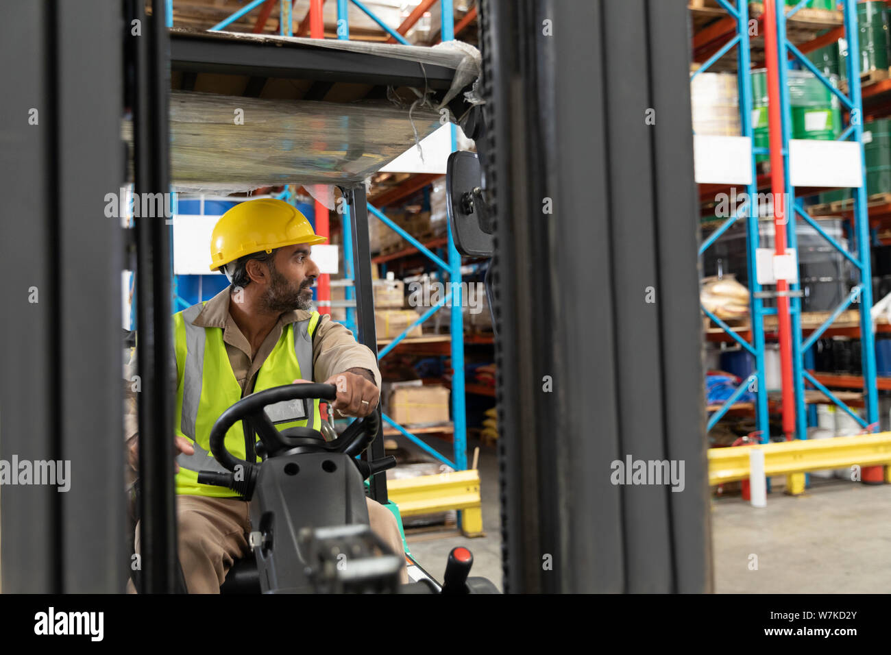 Male staff driving forklift in warehouse Stock Photo - Alamy