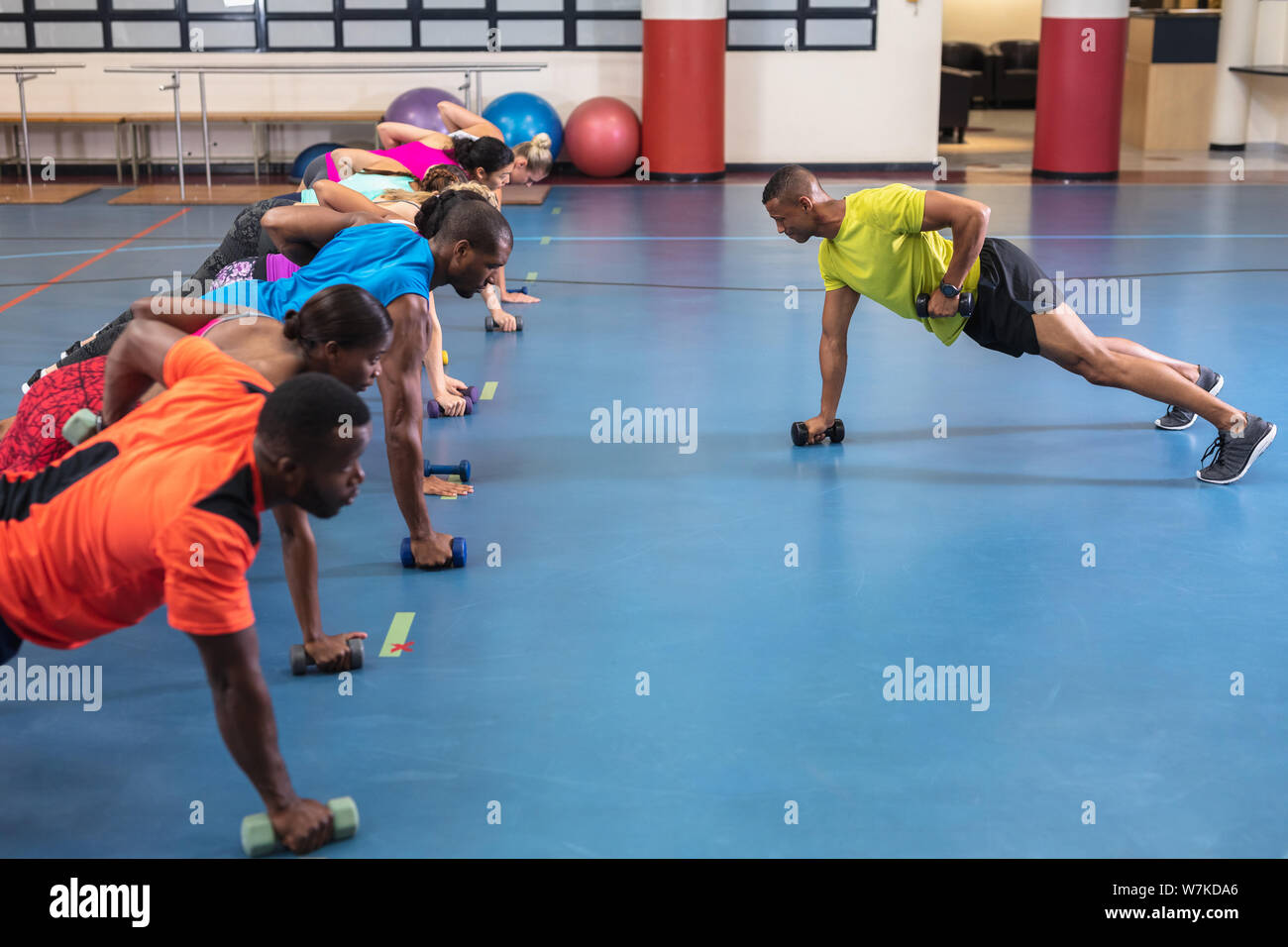 Male trainer training people to exercise with dumbbells Stock Photo - Alamy