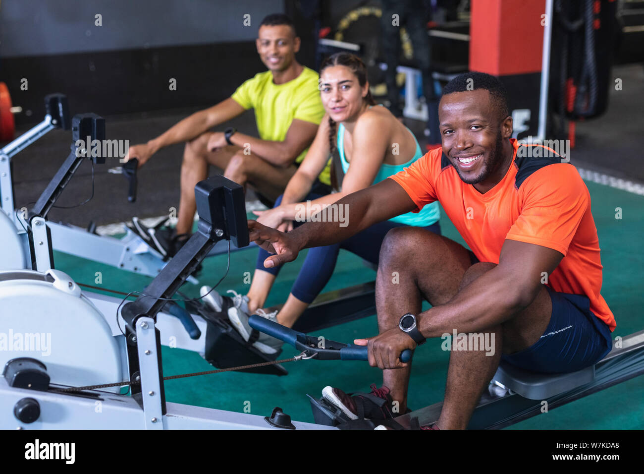 Fit people exercising with rowing machine in fitness center Stock Photo ...
