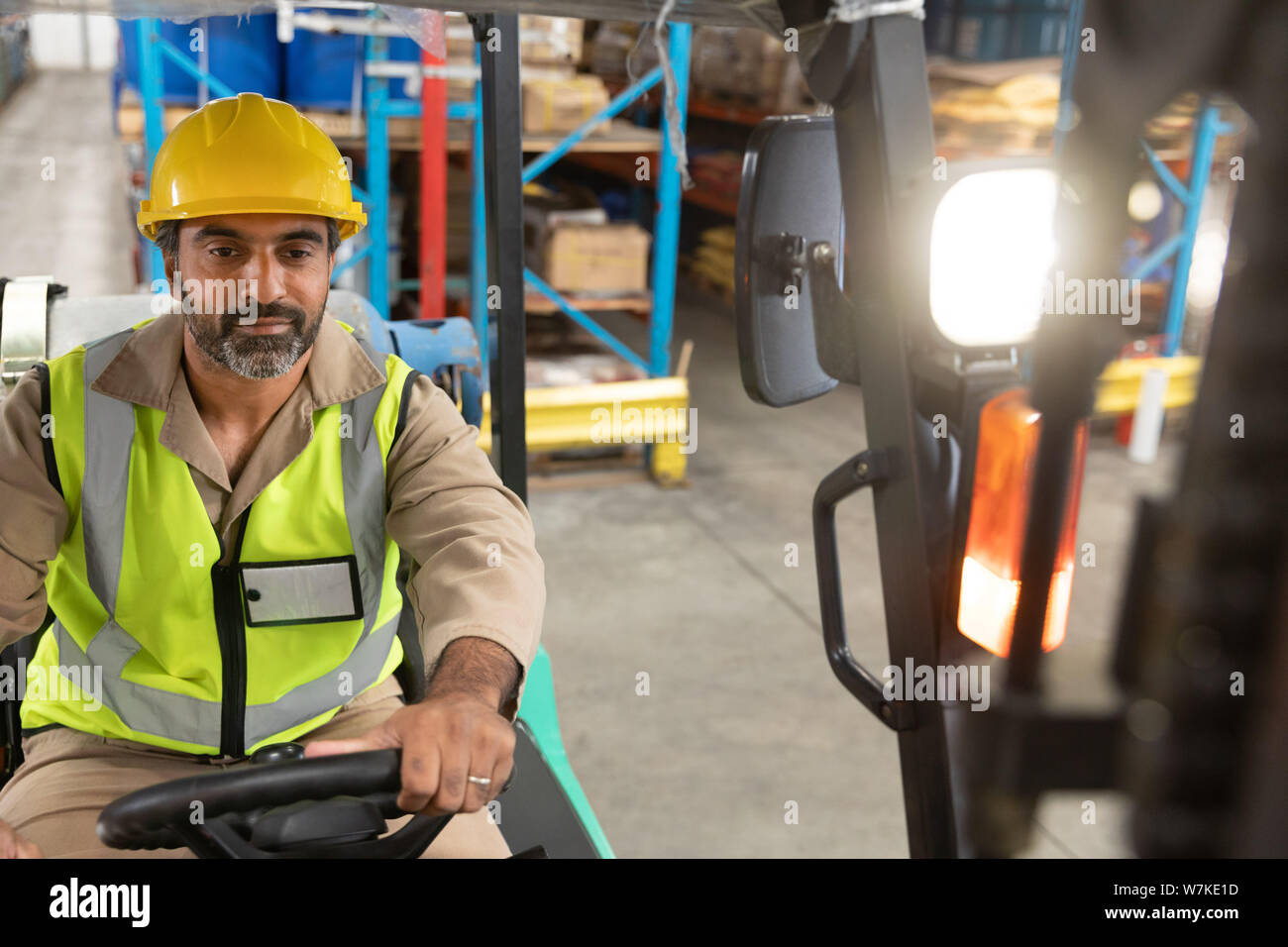 Male staff driving forklift in warehouse Stock Photo - Alamy