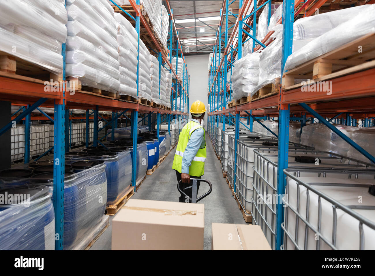 Male staff using pallet jack in warehouse Stock Photo - Alamy