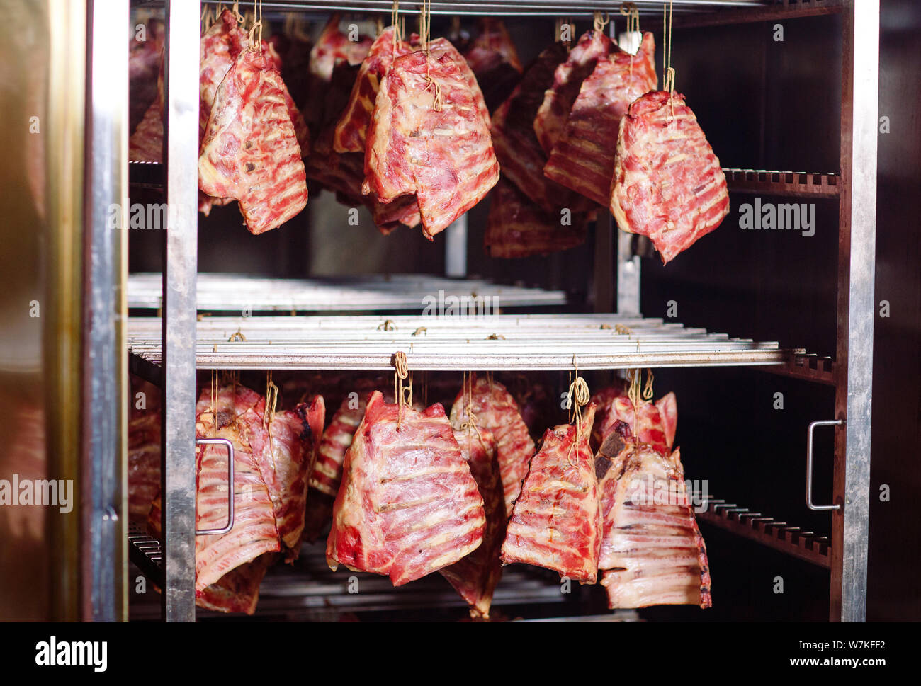 smoking meat in the smokehouse, the meat industry Stock Photo - Alamy