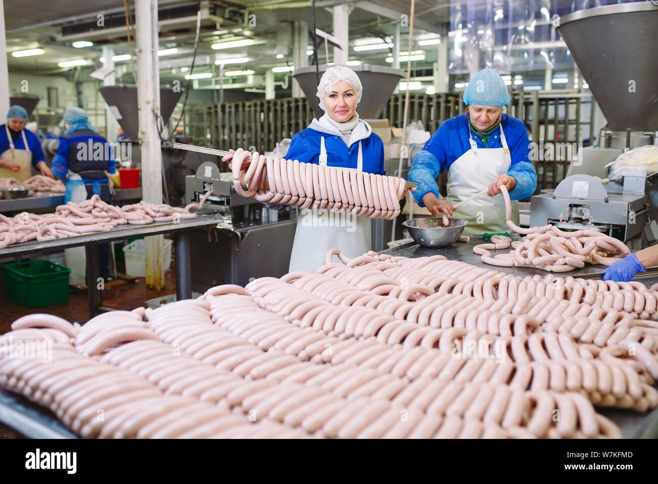Butchers processing sausages at the meat factory Stock Photo - Alamy