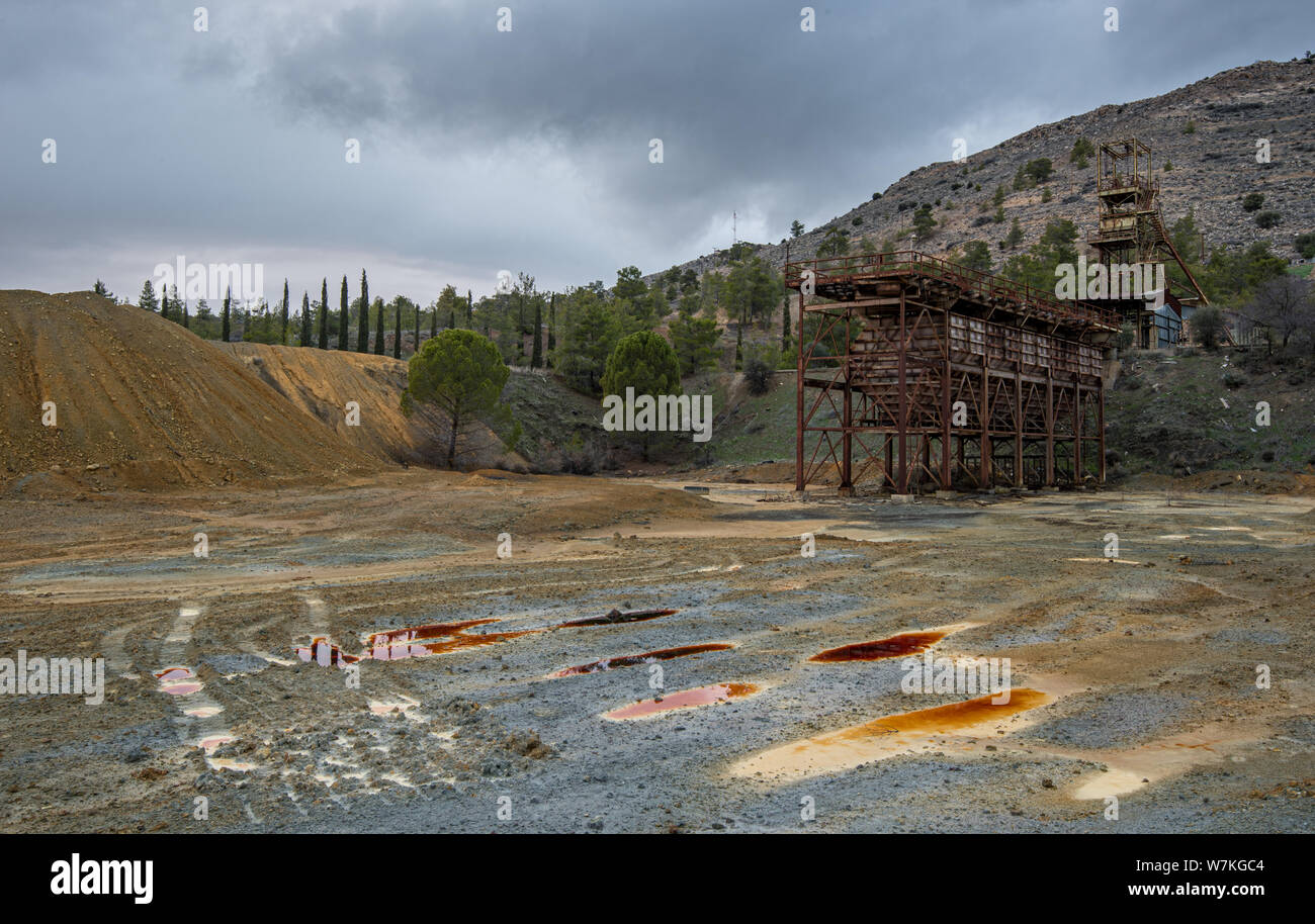 Abandoned copper mine with red toxic water and dramatic stormy cloudy ...