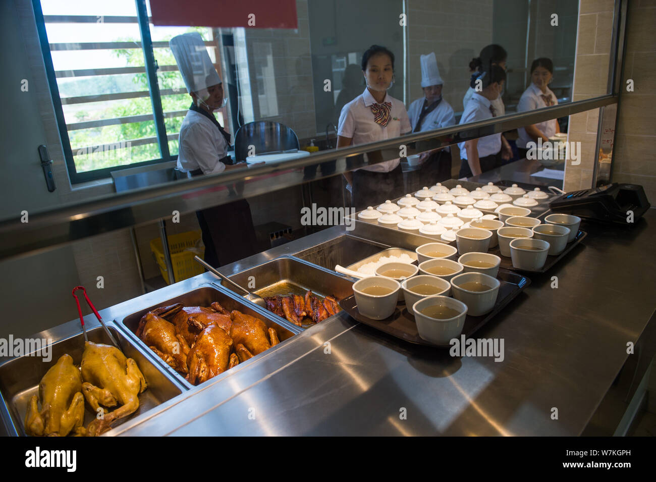Chinese employee serves food at a canteen of the Shenzhen Technology ...