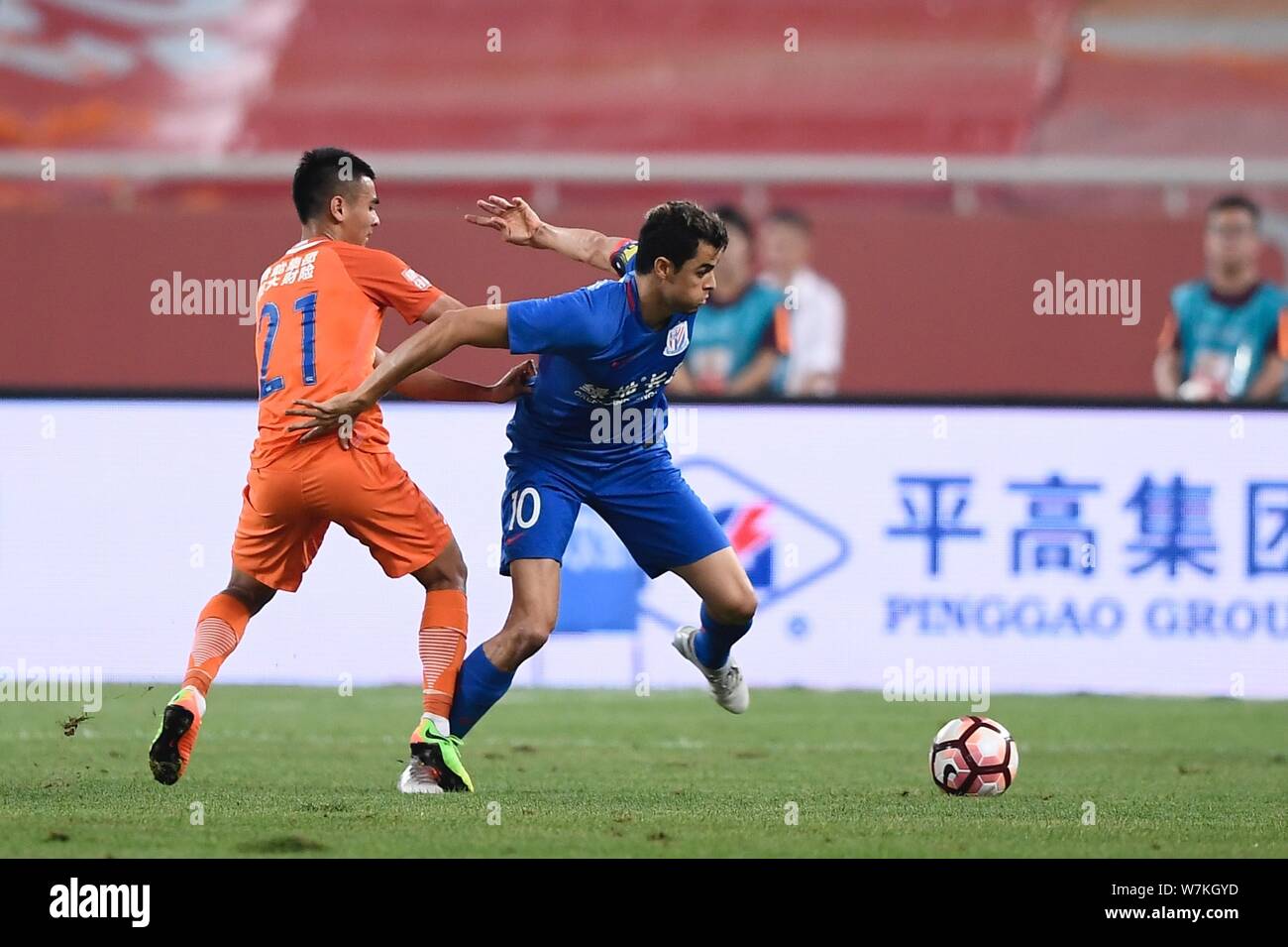 Colombian football player Giovanni Moreno, right, of Shanghai Greenland Shenhua kicks the ball ...