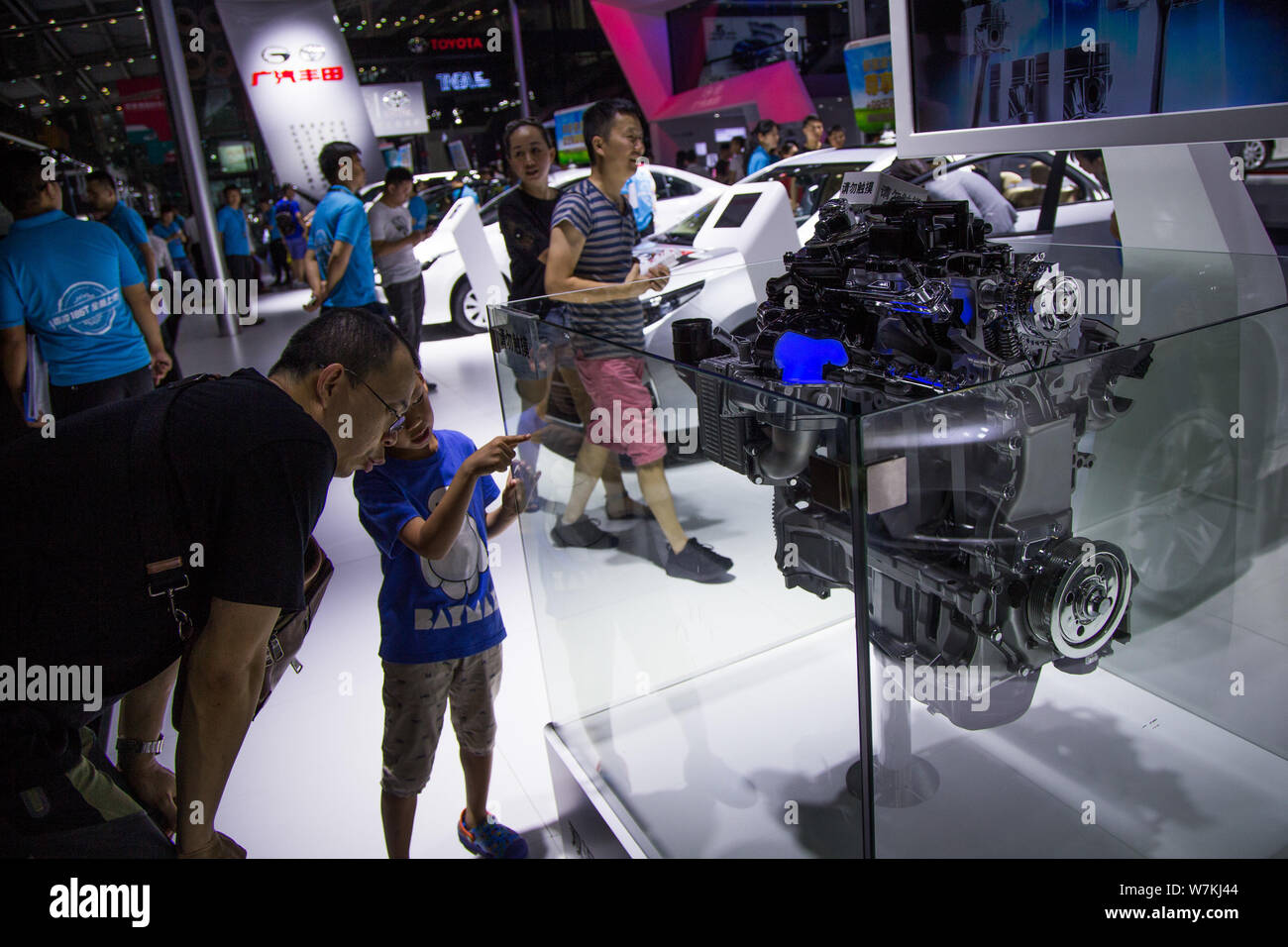 --FILE--Visitors look at an engine at the stand of GAC Toyota during ...