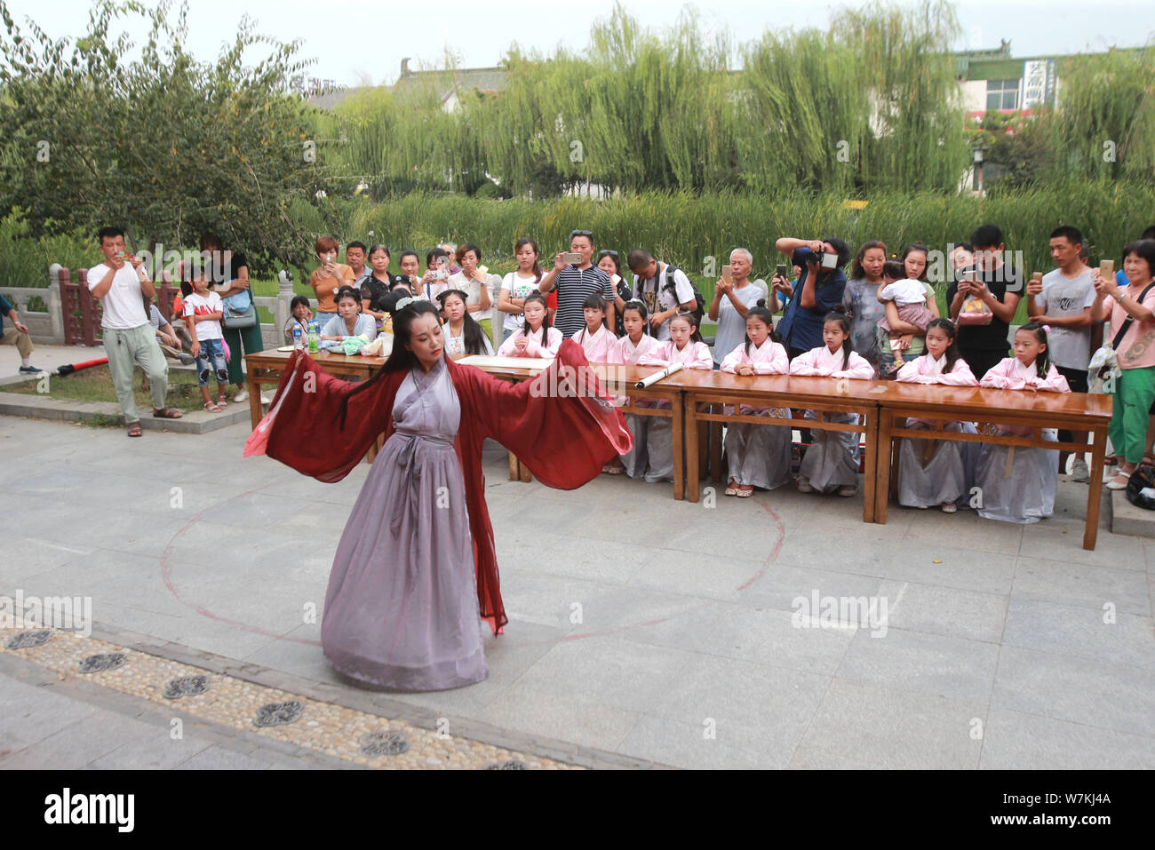 A Chinese woman dressed in traditional costume performs during a ...