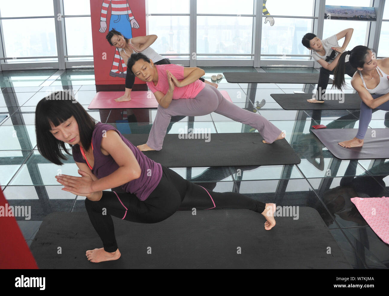 Chinese office ladies practice yoga on the 100th floor of the Shanghai ...