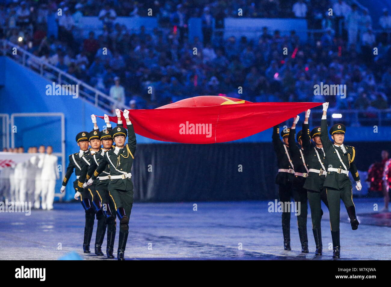 China's National Flag is carried to the stadium during the opening ...