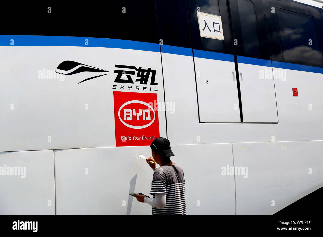 A Chinese employee installs a train of a new "SkyRail" monorail system ...