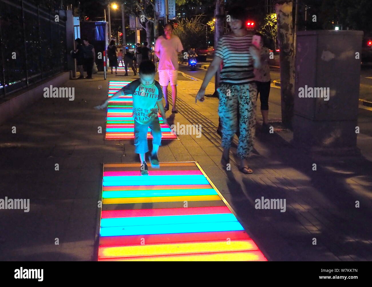 Local residents walk on the promenade featuring colourful LED lights in ...