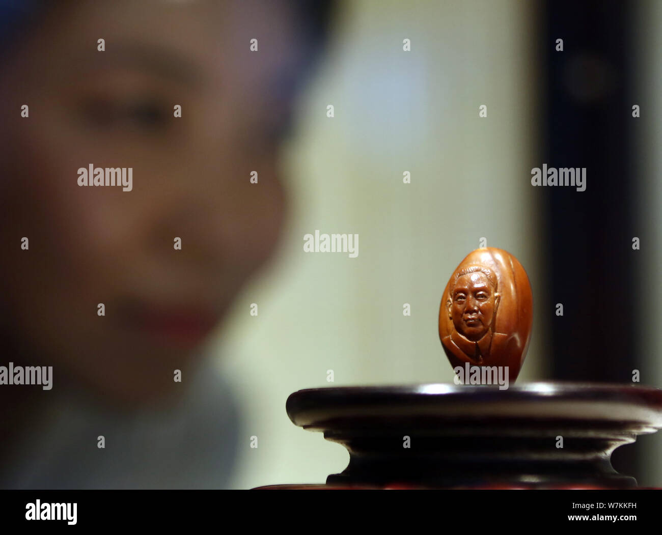 A visitor looks at a fruit pit carving on display during a carving ...
