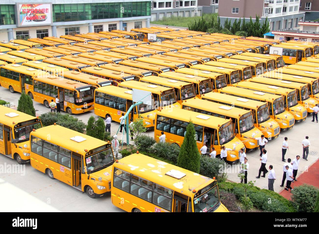 Chinese workers are seen after checking the yellow school buses before ...