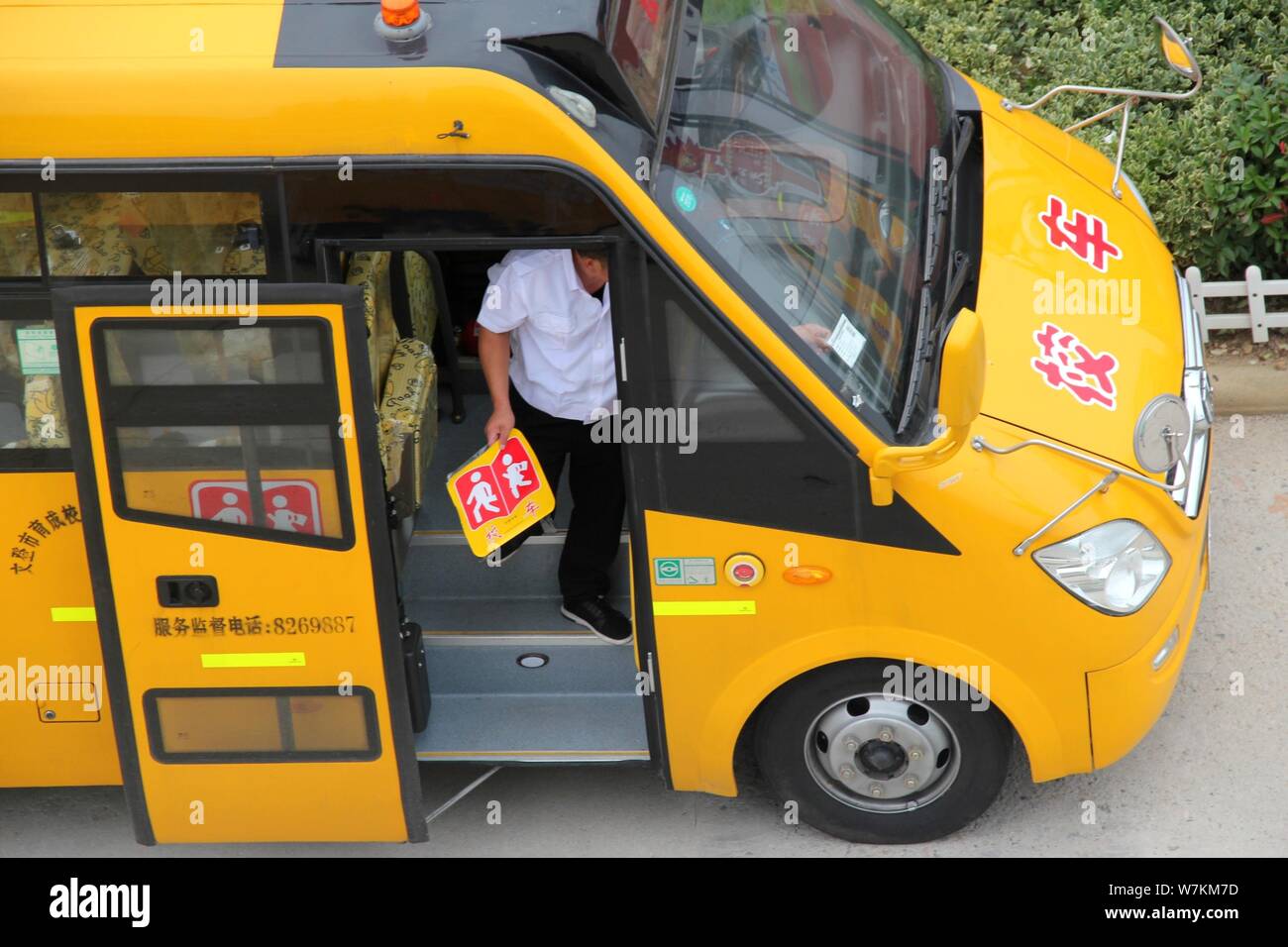 A Chinese worker checks the yellow school buses before the start of a ...