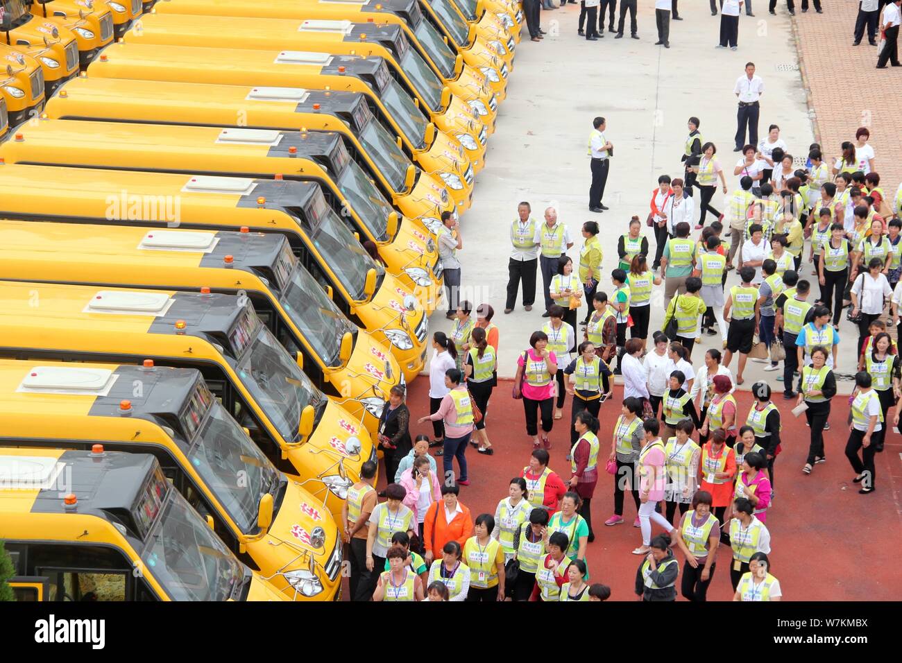 Chinese workers are seen after checking the yellow school buses before ...