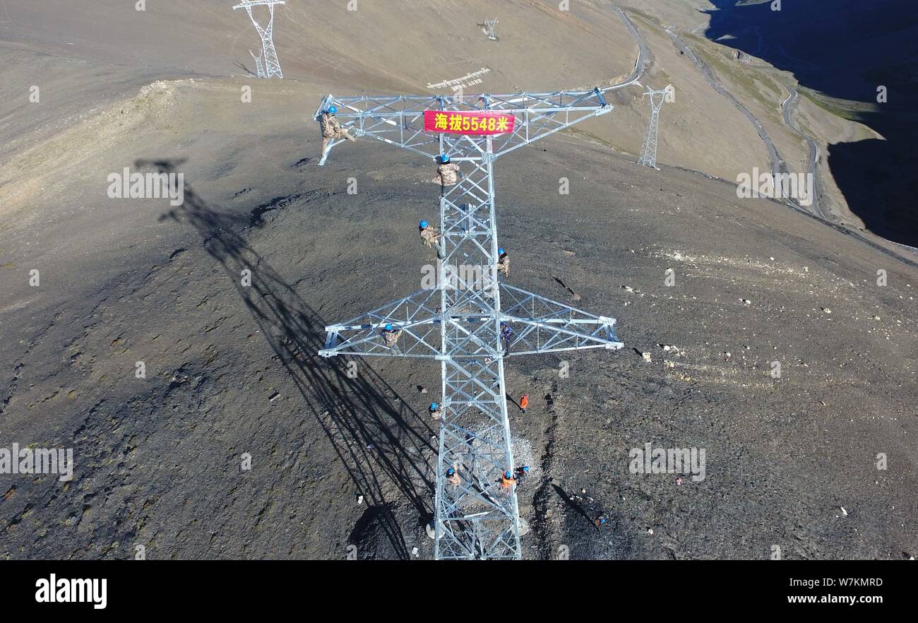 Electricity workers are assembling the highest power transmission tower in the world with a ...