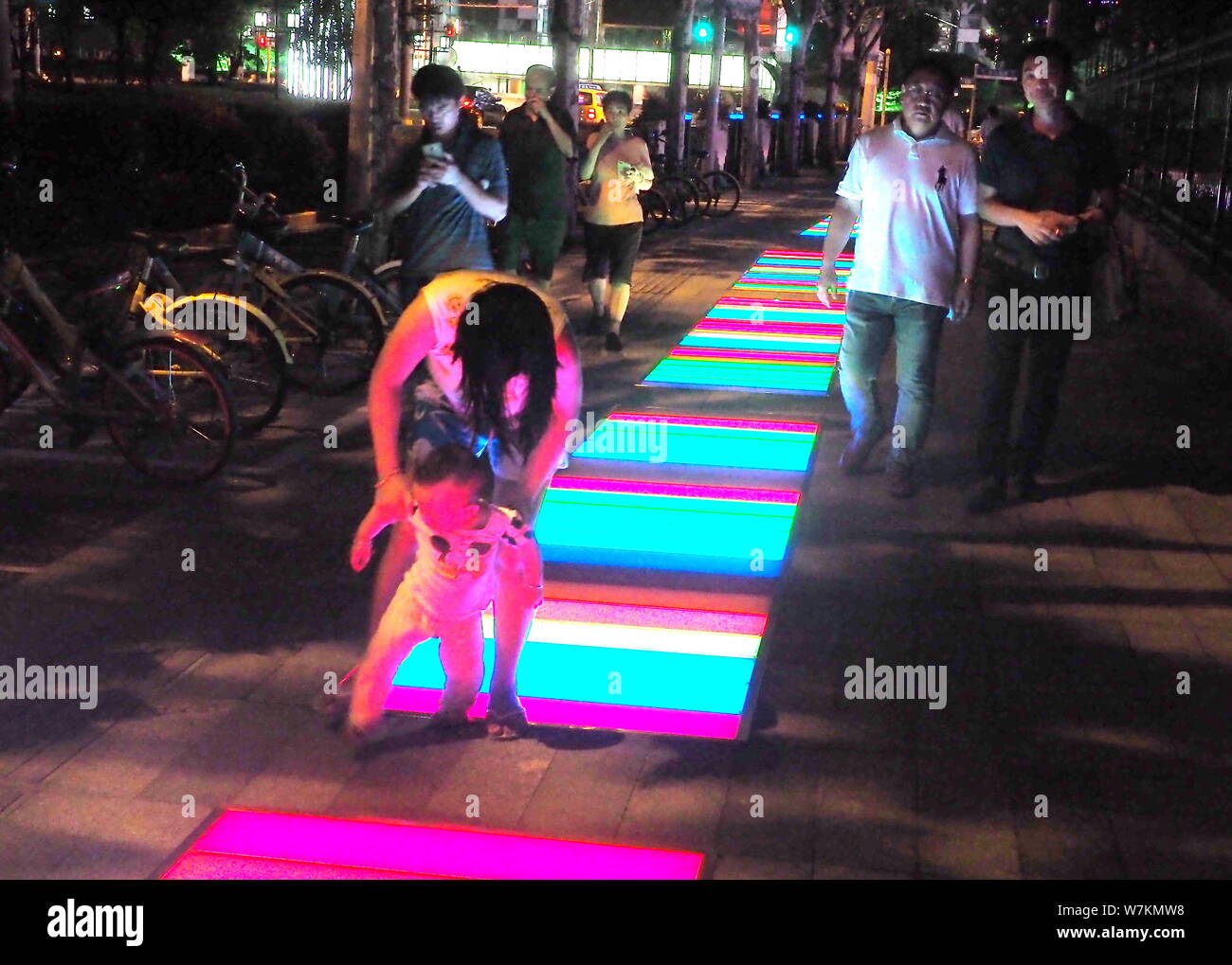 Local residents walk on the promenade featuring colourful LED lights in ...