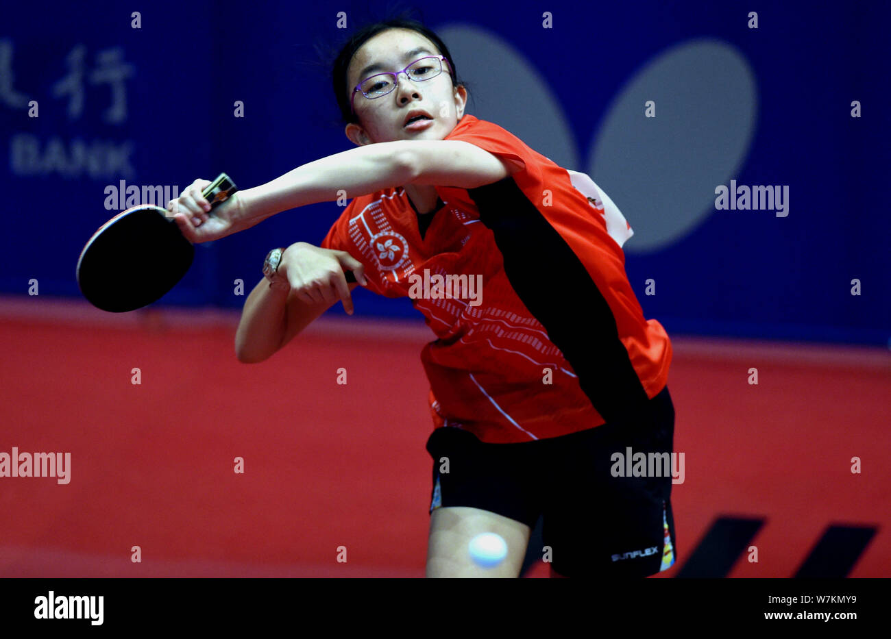Ng Wing Lam of Hong Kong returns a shot as she and Lee Ka Yee compete ...