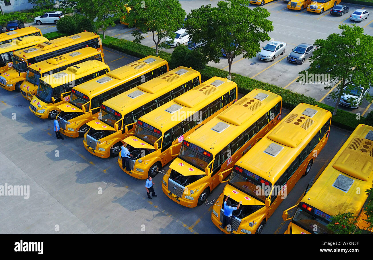 School bus drivers check yellow school buses before the start of a new ...