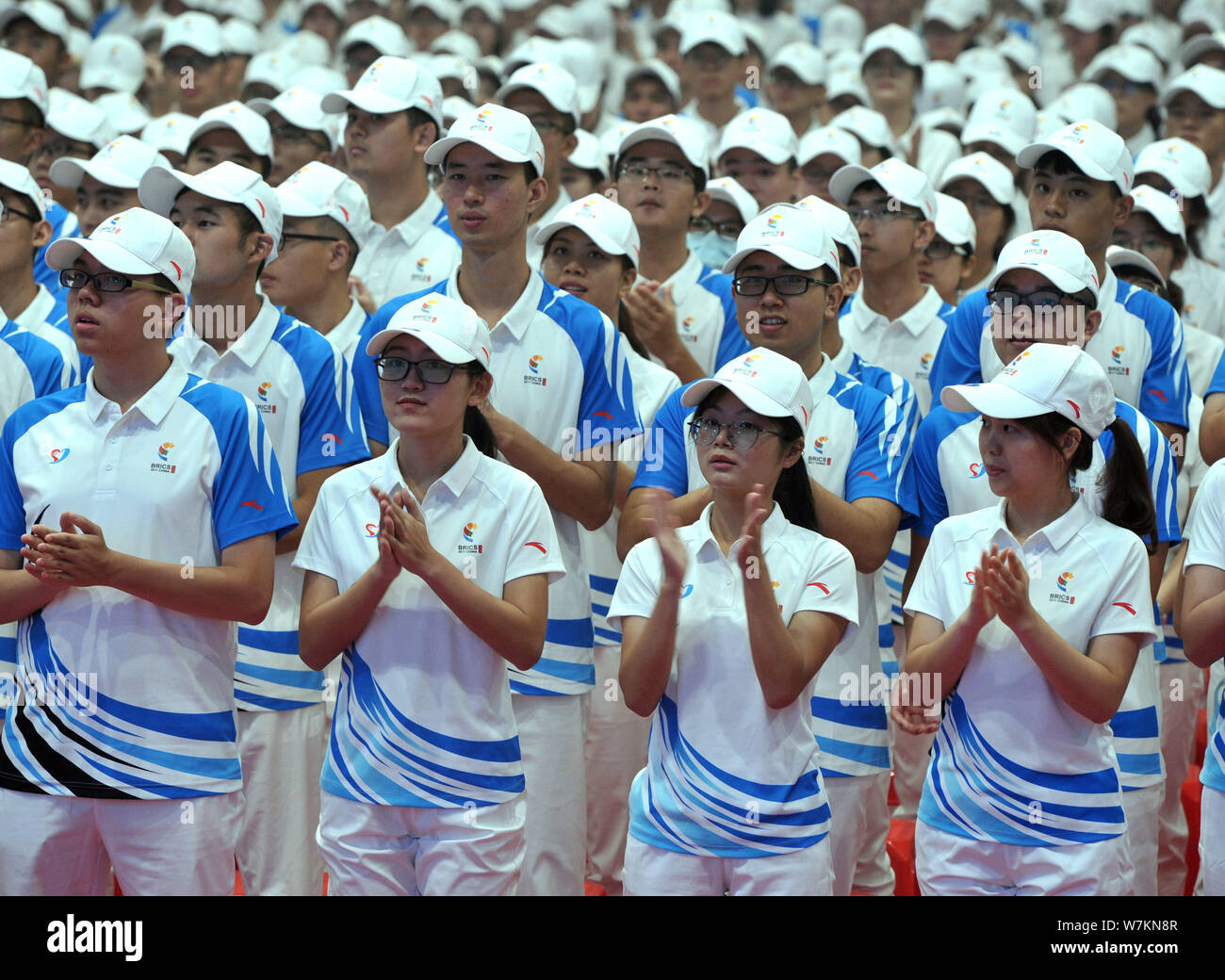 Chinese volunteers dressed in uniforms watch representatives displaying ...