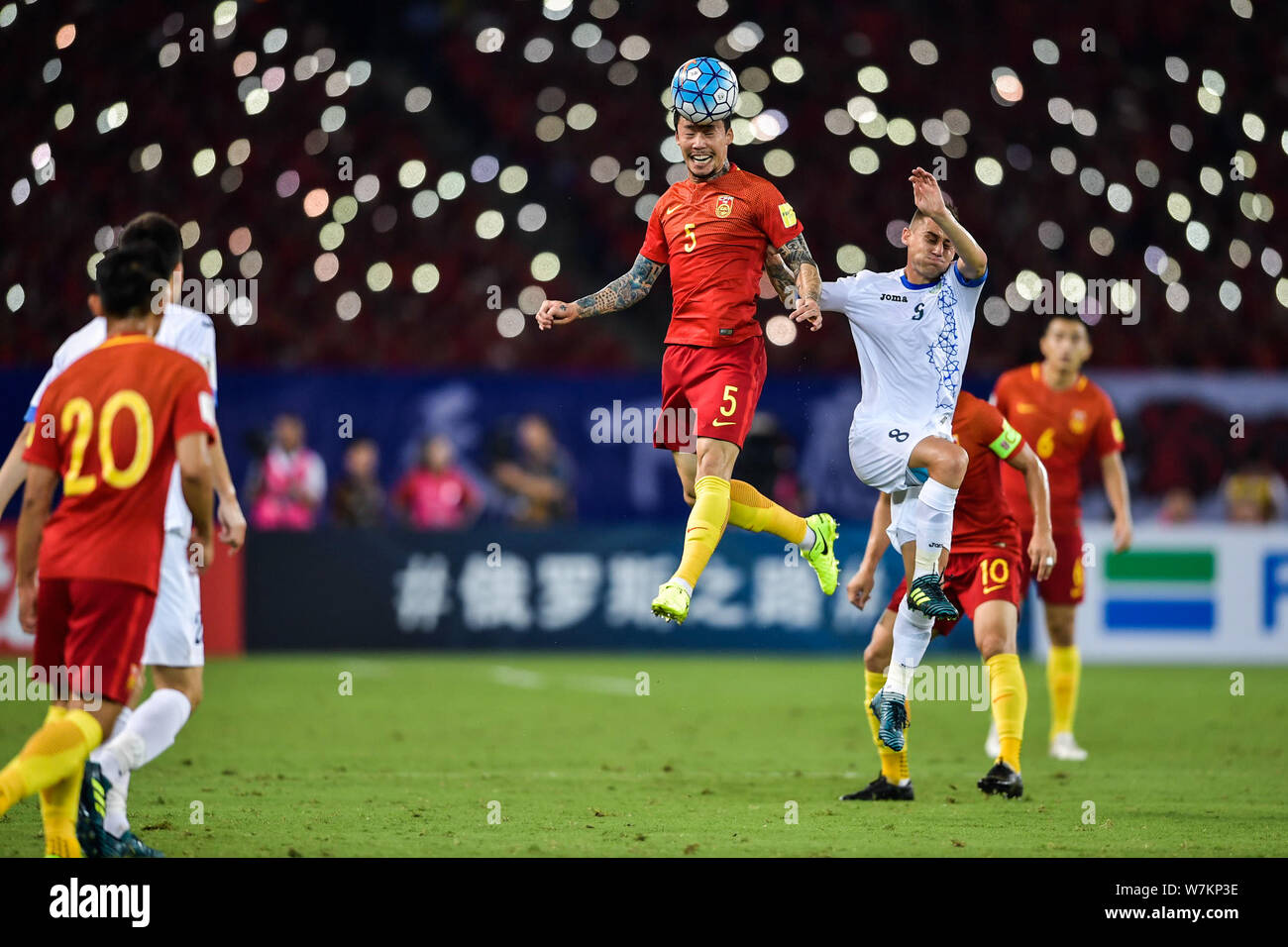 Zhang Linpeng, left, of China heads the ball to make a pass against ...