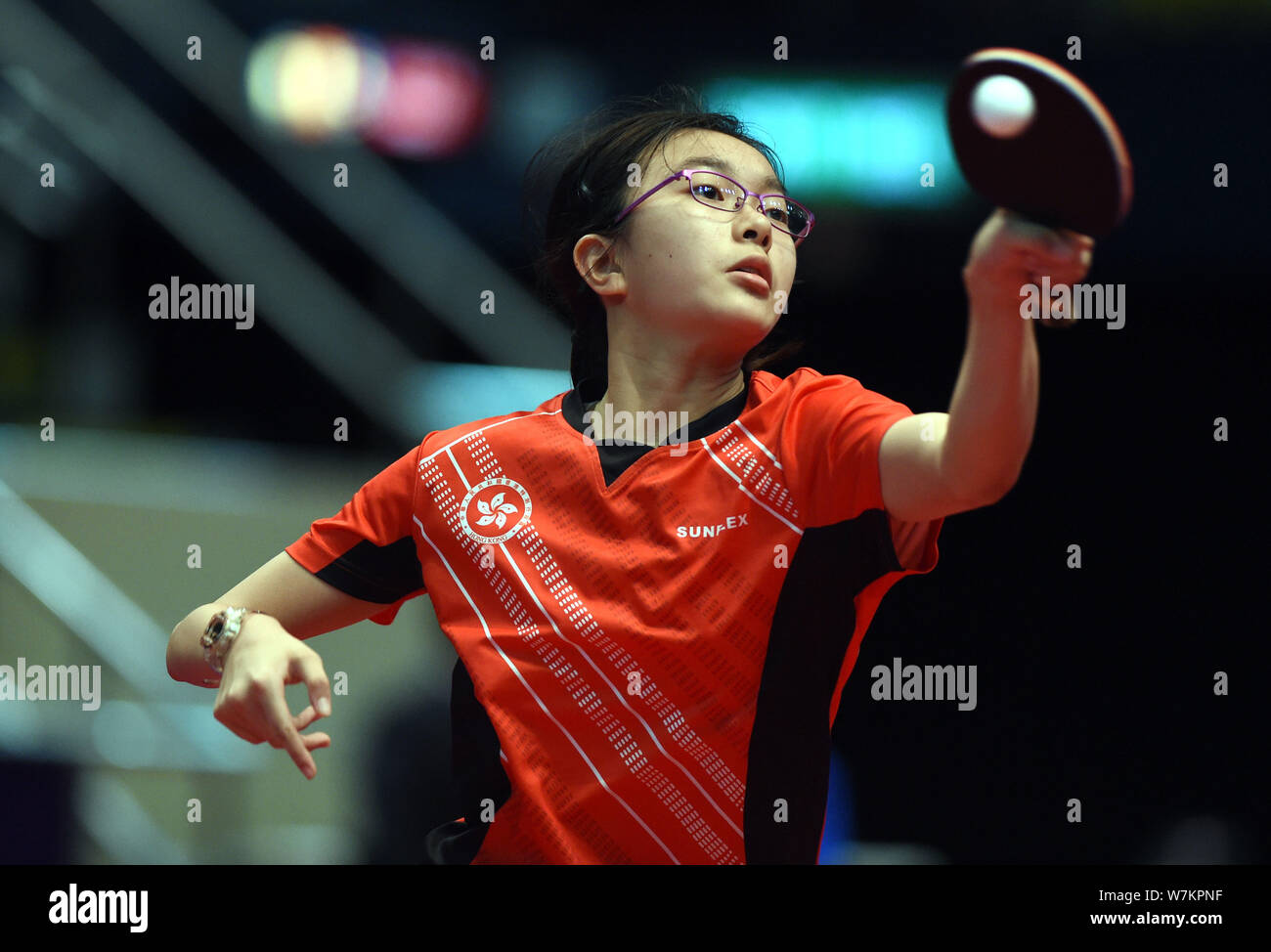Ng Wing Lam of Hong Kong returns a shot as she and Lee Ka Yee compete ...